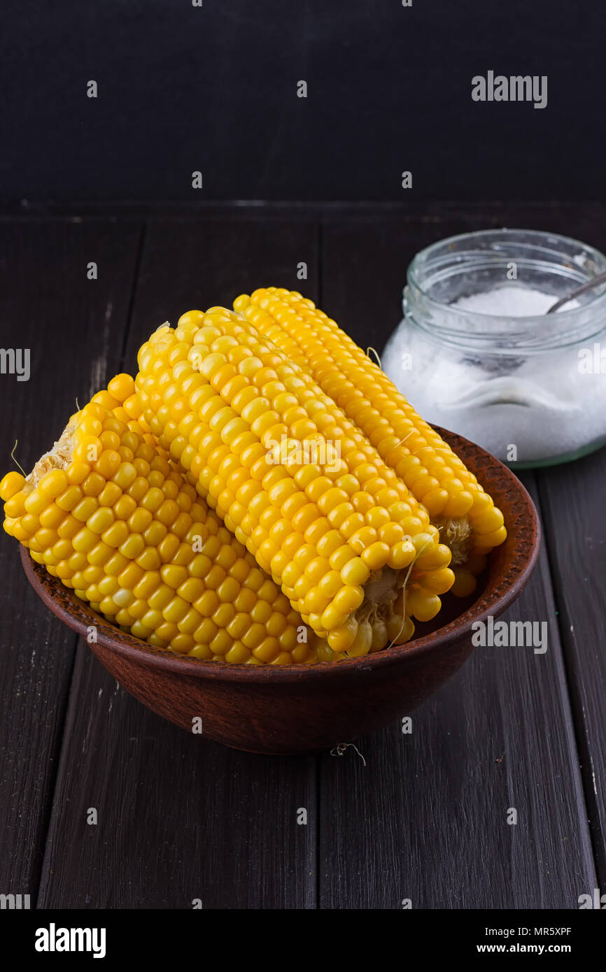 Homemade golden corn cob with salt on black background Stock Photo - Alamy