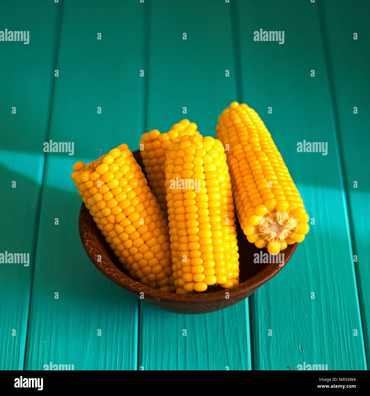 Boiled corn on a blue wood background Stock Photo - Alamy
