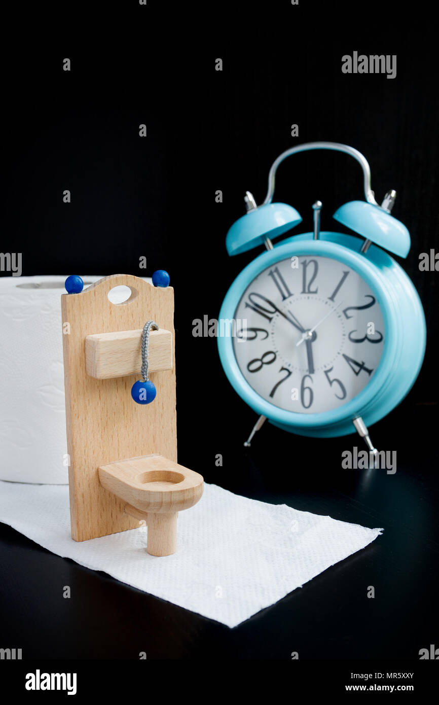 Wooden toy toilet and alarm clock on black background Stock Photo - Alamy