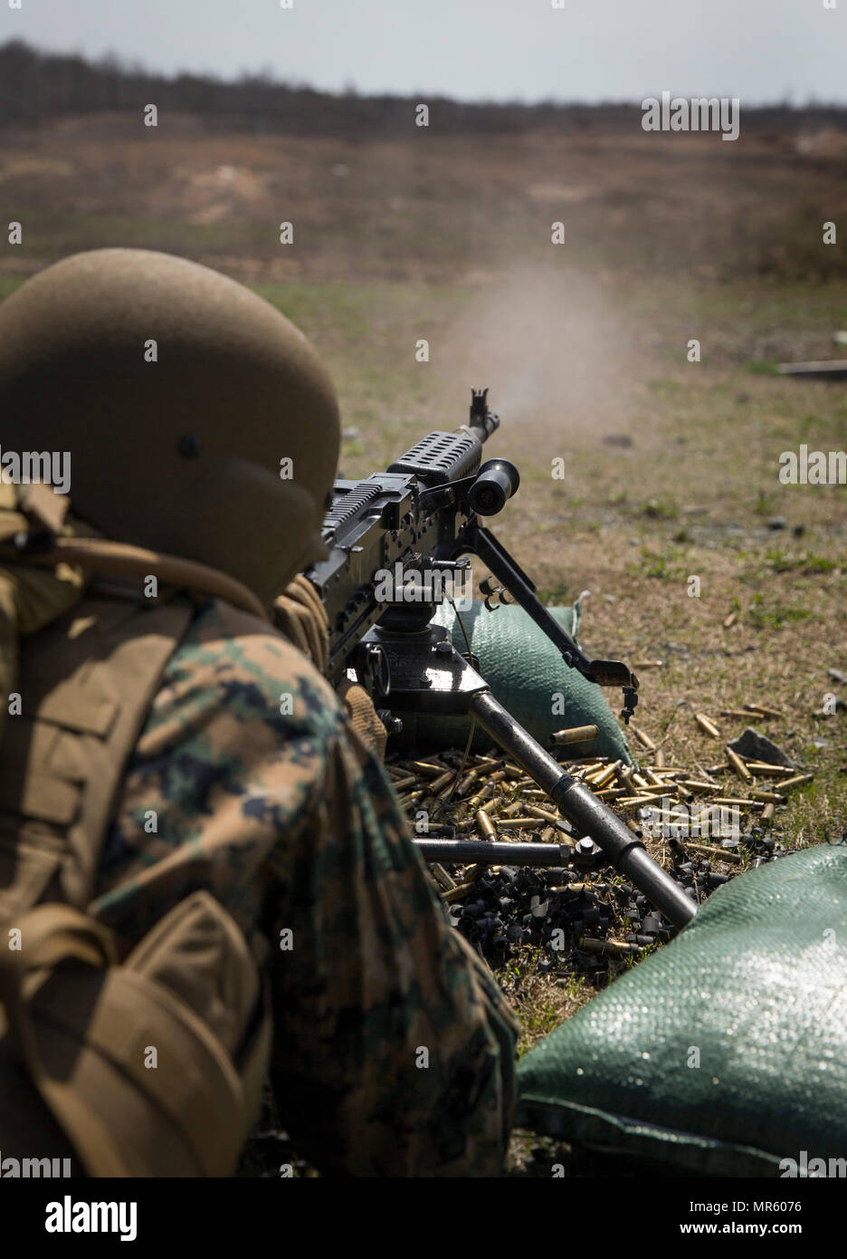 A U.S. Marine with Headquarters and Service Battalion fires the M240B ...