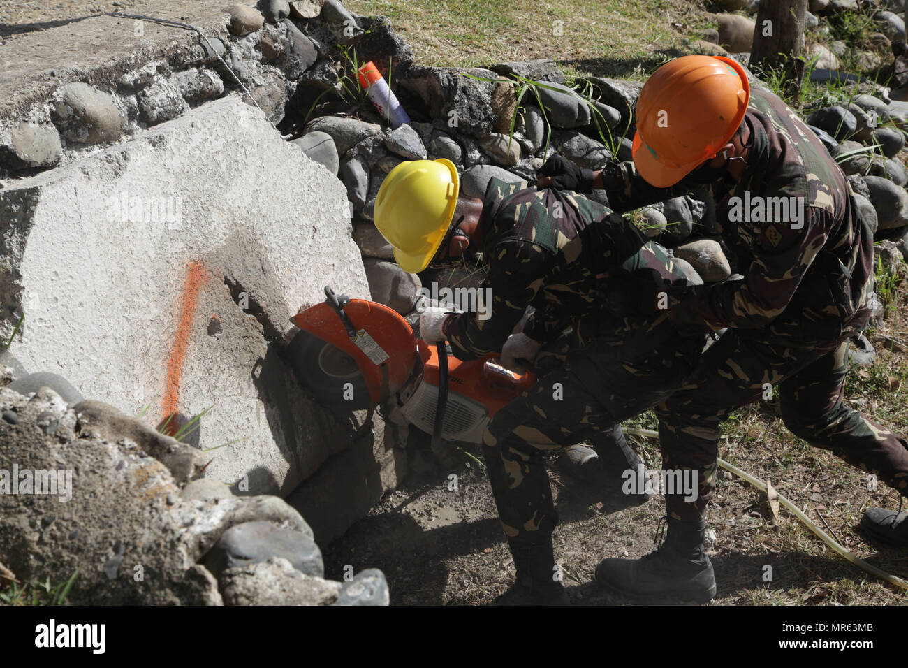 Philippine Soldiers cut debris to rescue a training dummy that is ...