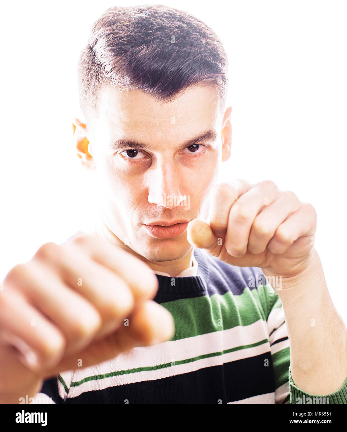Portrait of a smart serious young man standing against white background ...