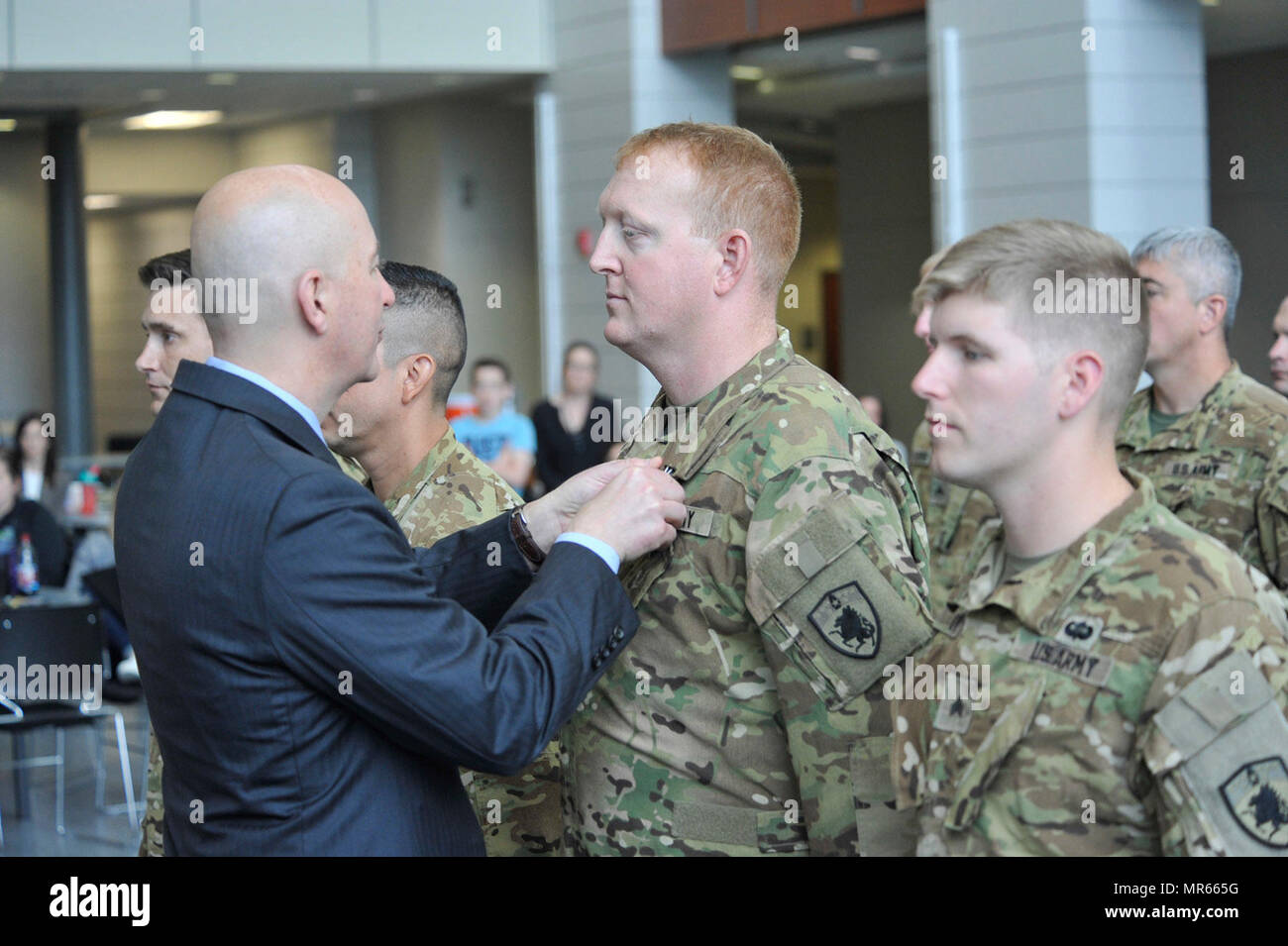 Nebraska Governor Pete Ricketts pins on a blue and gold Air Medal with ...