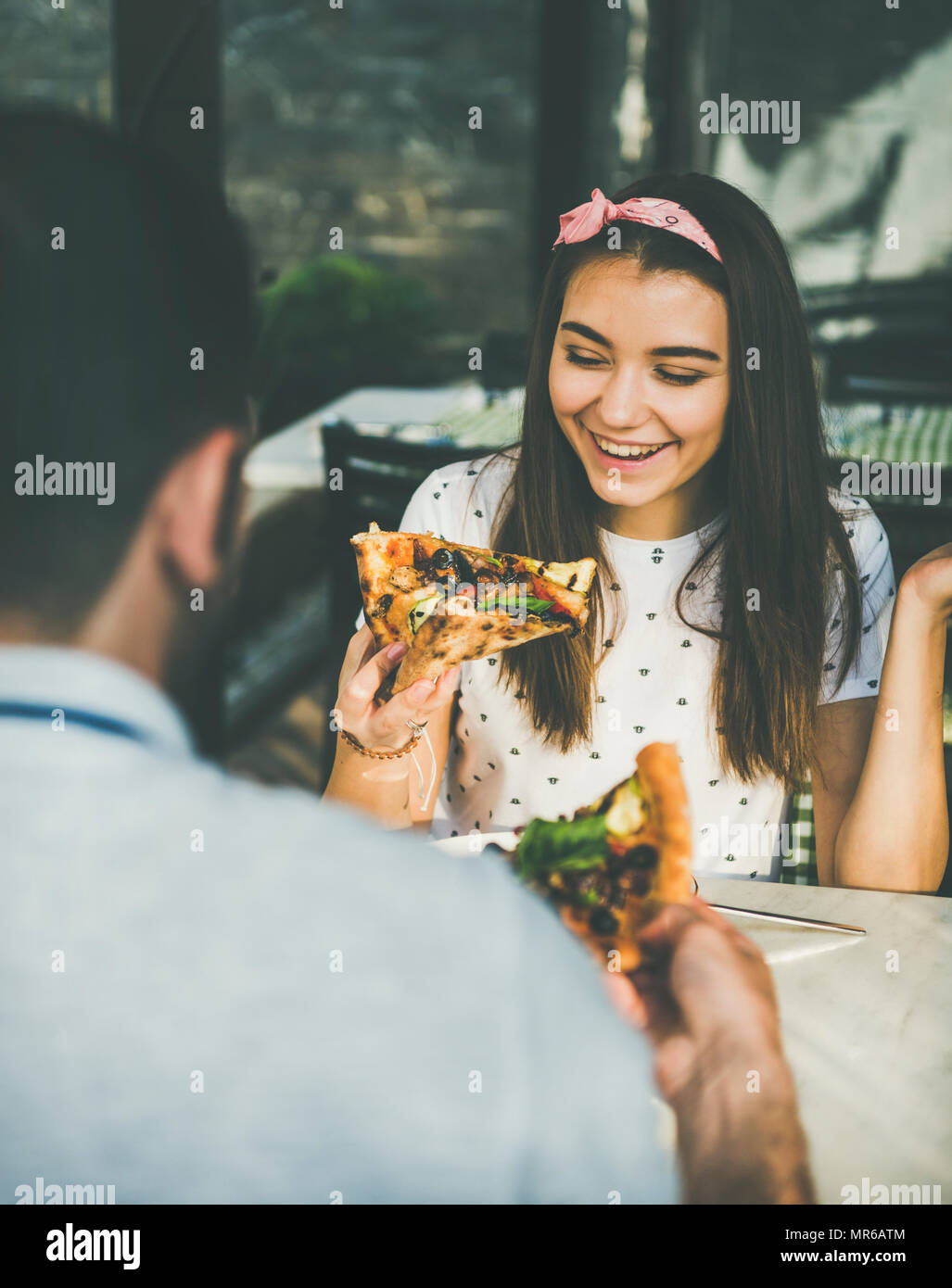 Couple eating pizza at table hi-res stock photography and images - Alamy