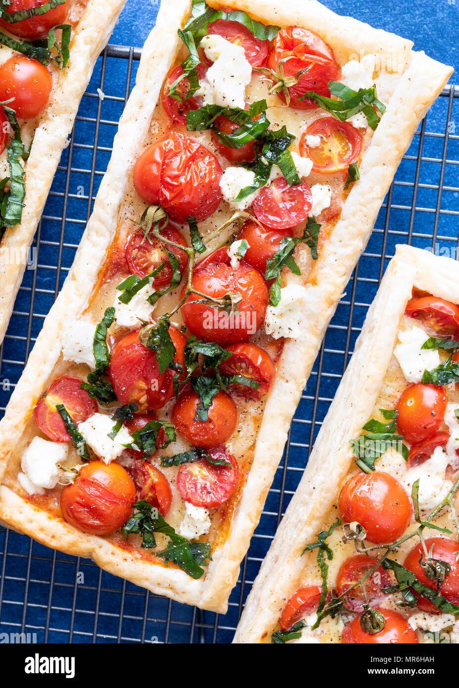 Rectangular savoury tart filled with cherry tomatoes, feta cheese and ...