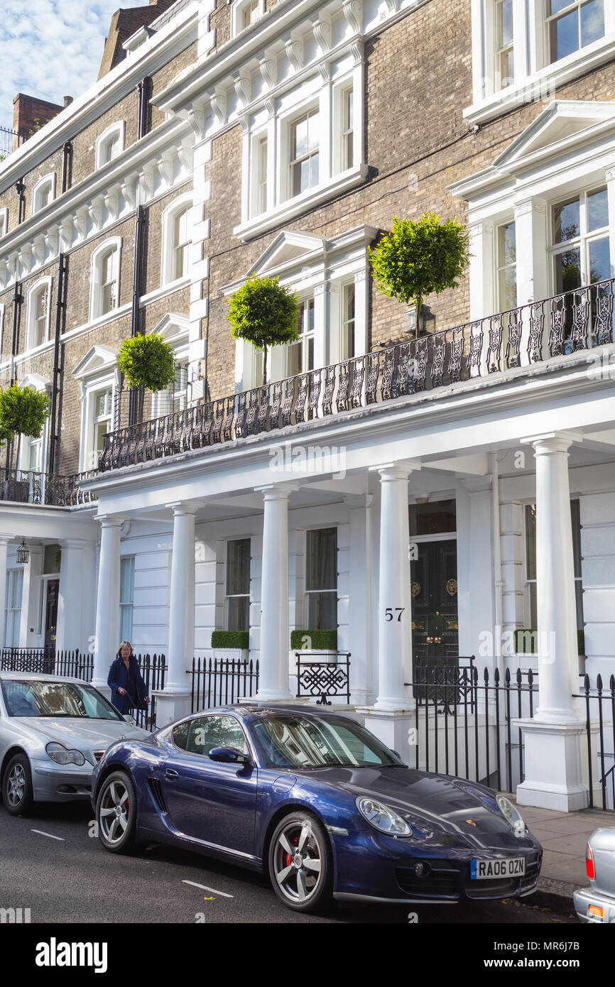 Upmarket stucco terrace townhouses with portico facades, with a parked ...