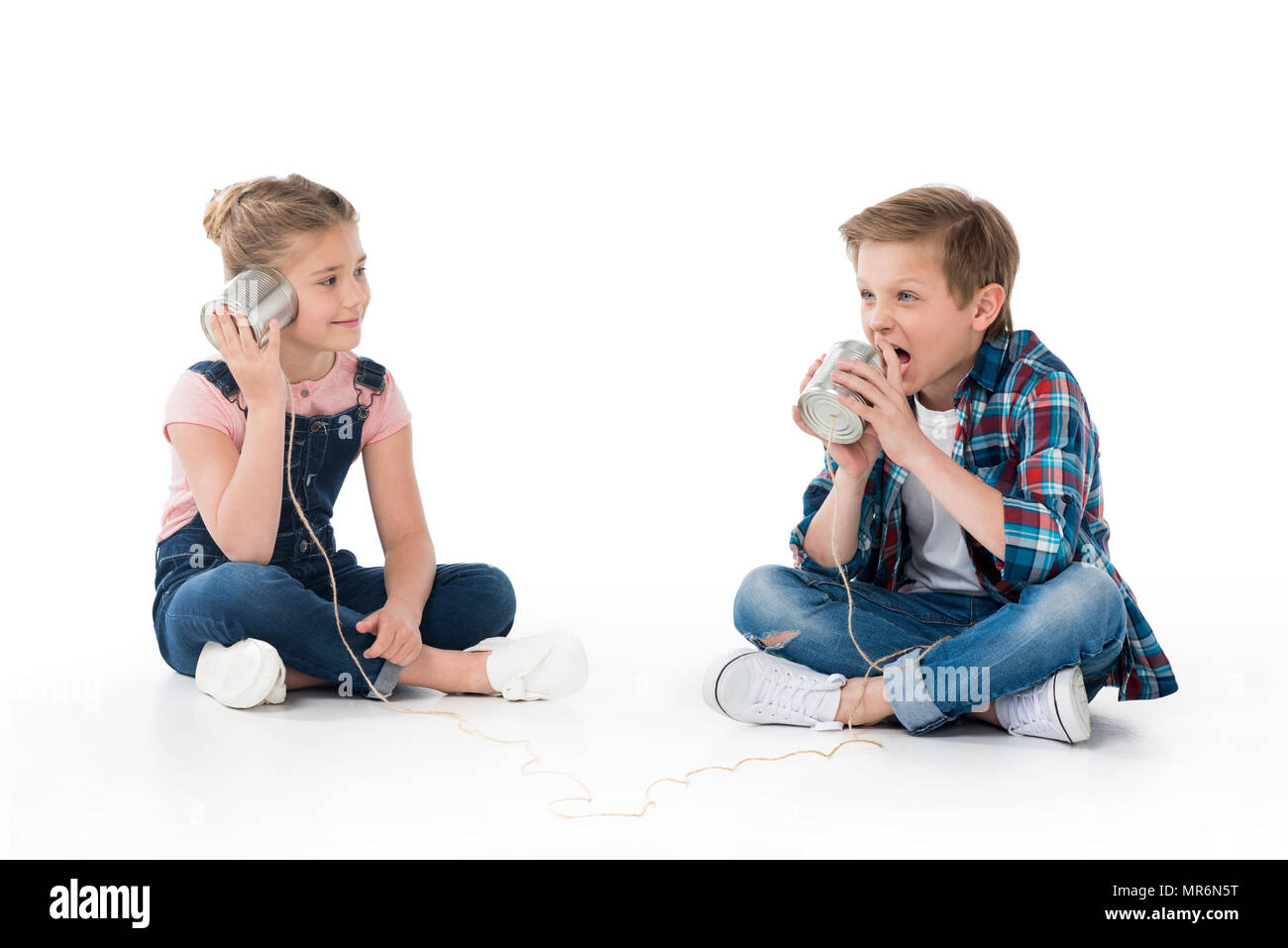 children using metal cups as telephone while playing together isolated ...
