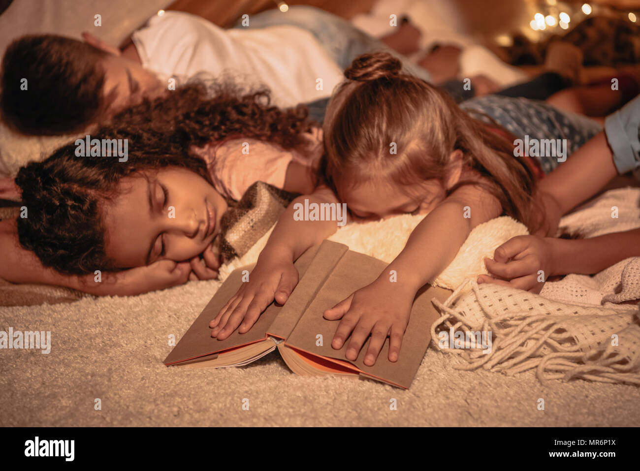 group of little children sleeping after reading book at home Stock ...