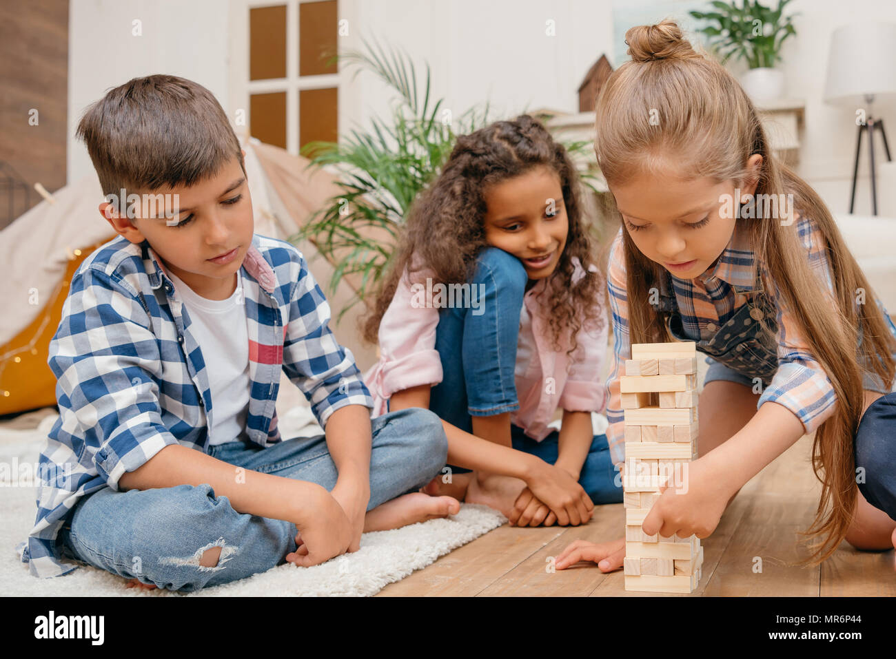 multicultural group of children playing blocks wood game together at ...