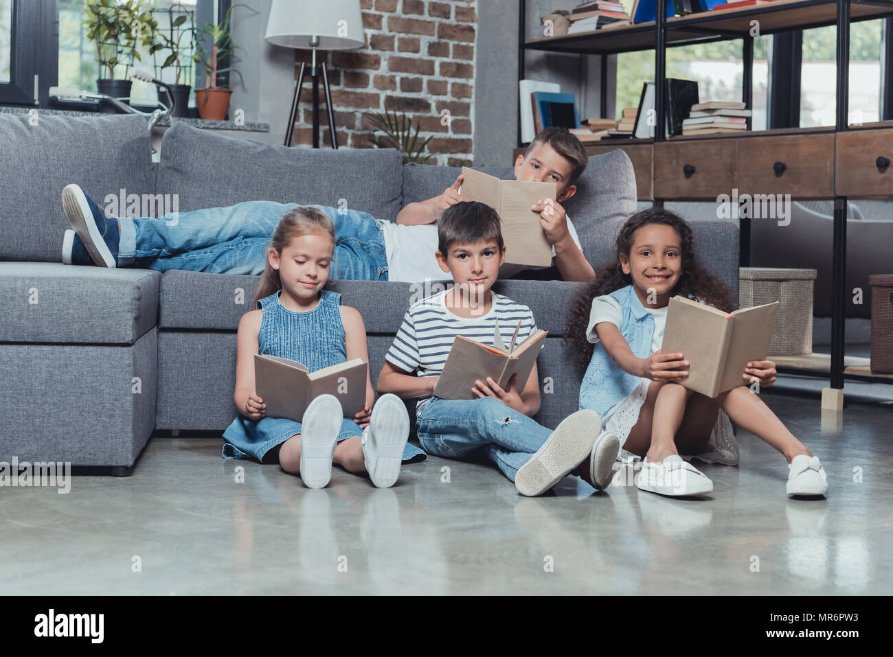 multicultural group of children reading books at home together Stock ...
