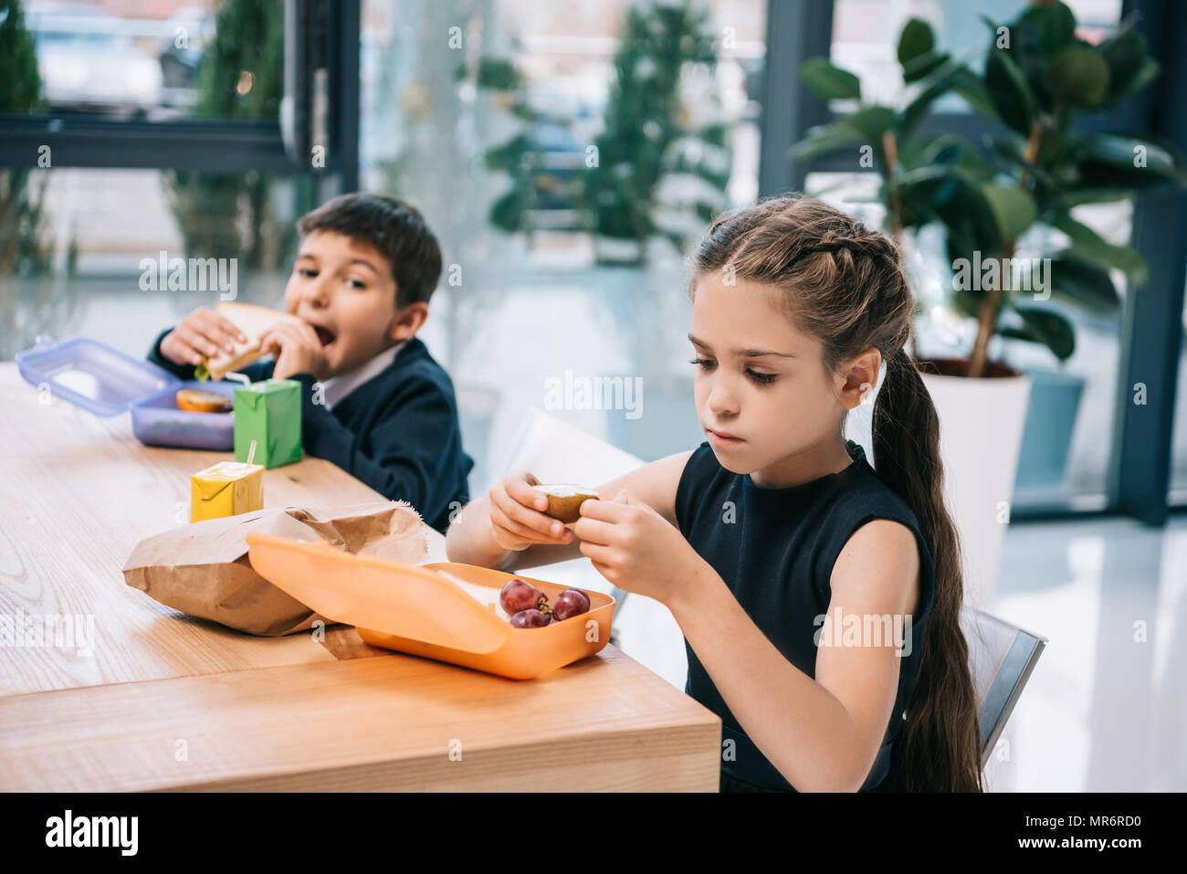 Cute little classmates eating lunch at break in school Stock Photo - Alamy