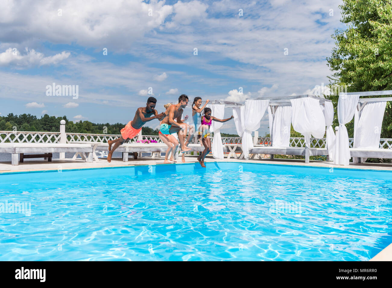 Group of beautiful young multiethnic people looking happy while jumping ...
