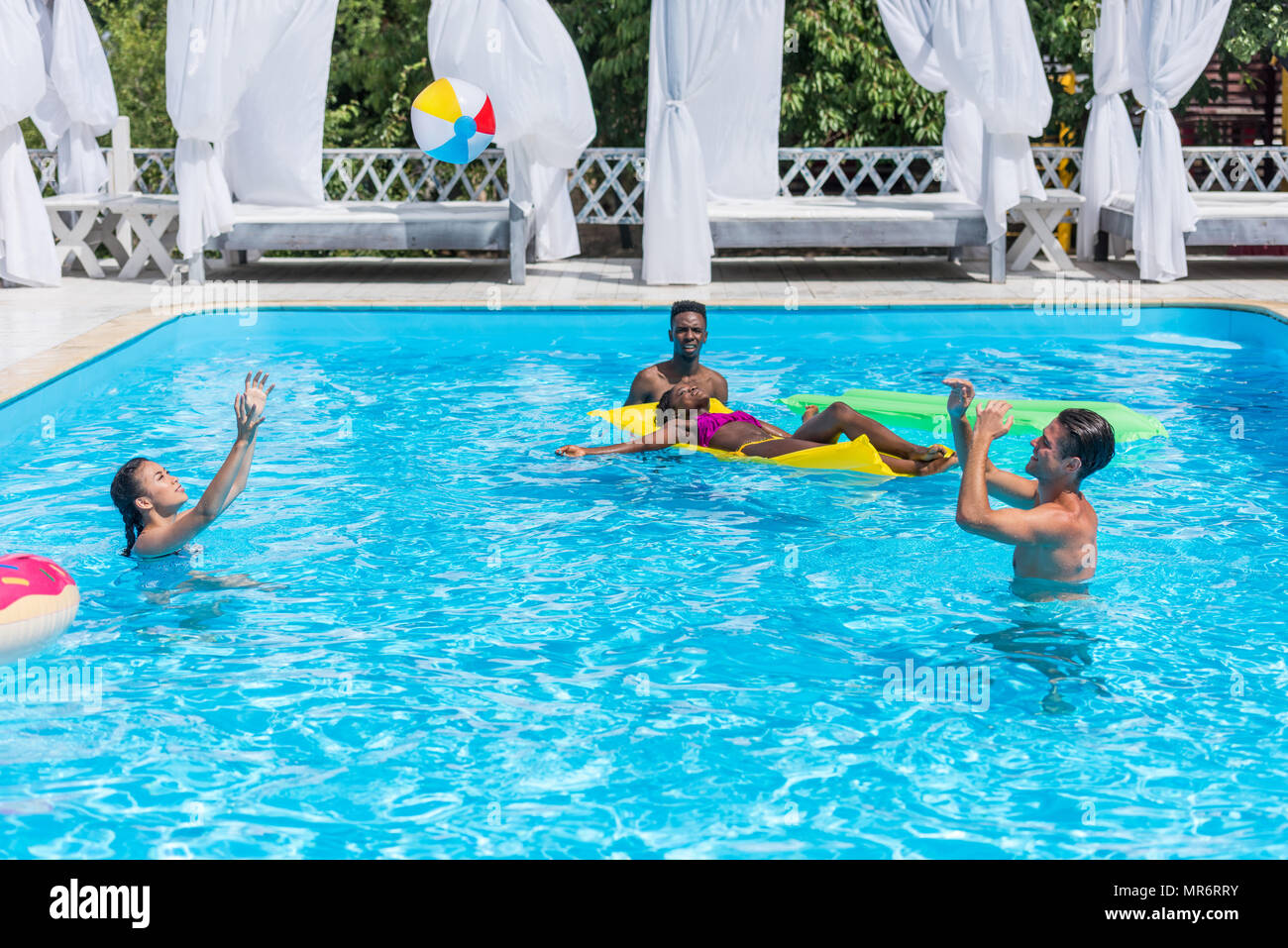 Group of young happy multiethnic people having fun together in swimming ...