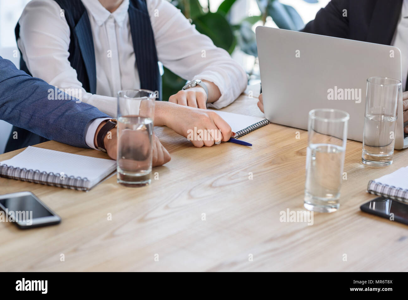 Colleagues writing in notepads during meeting in office Stock Photo - Alamy