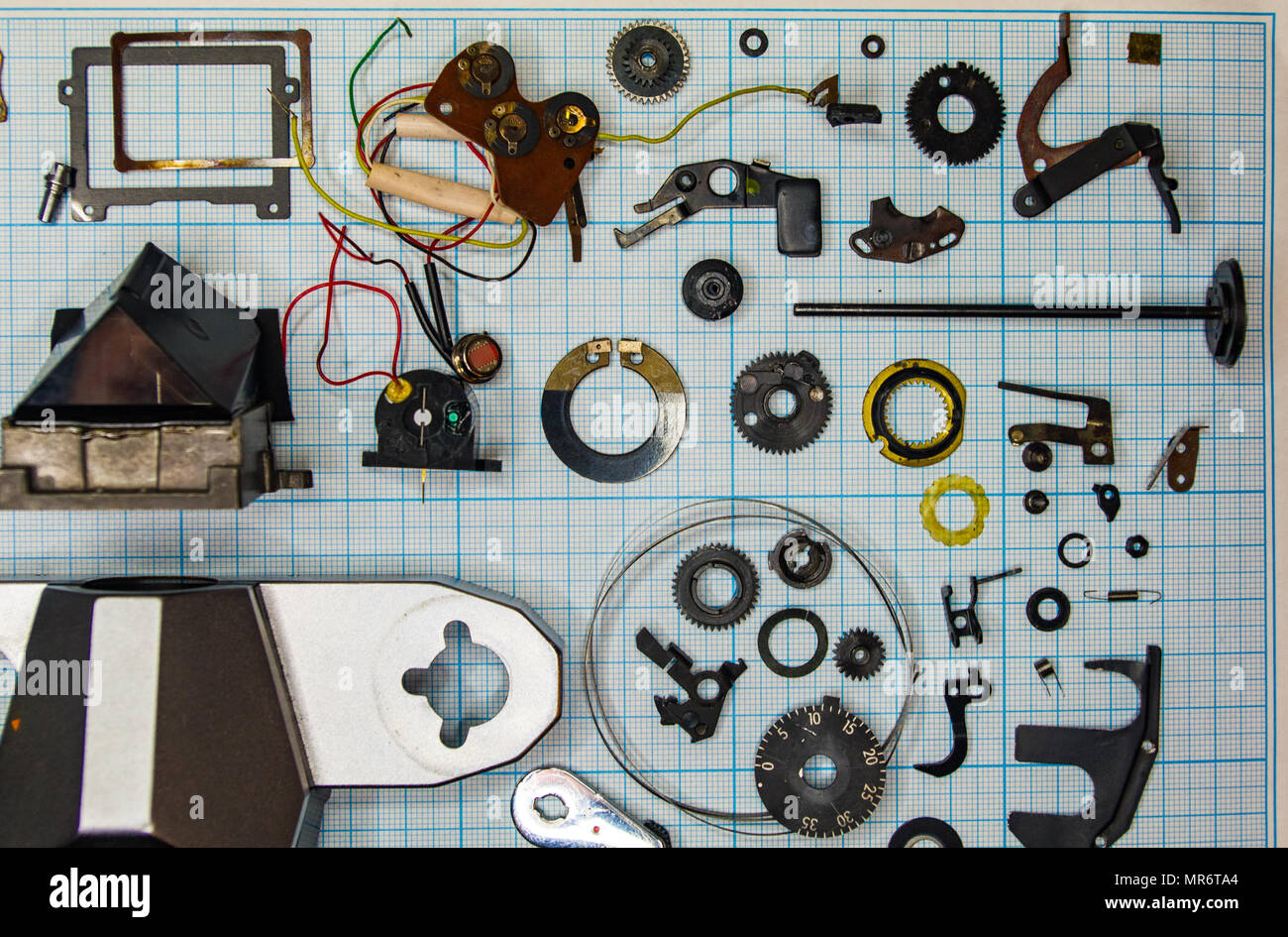 parts are completely disassembled old retro film SLR camera on graph ...