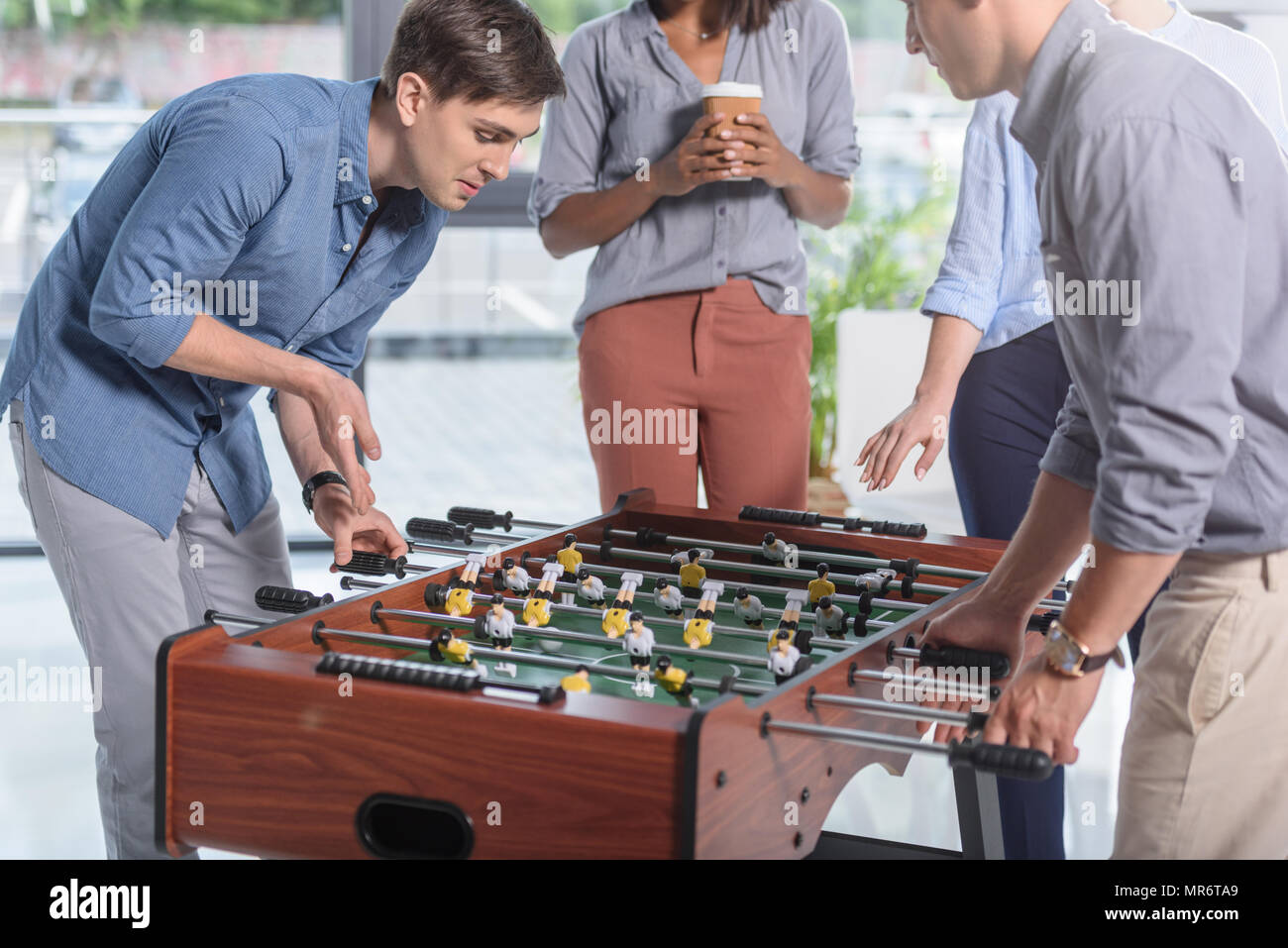 Young businessmen playing table football in modern office Stock Photo ...