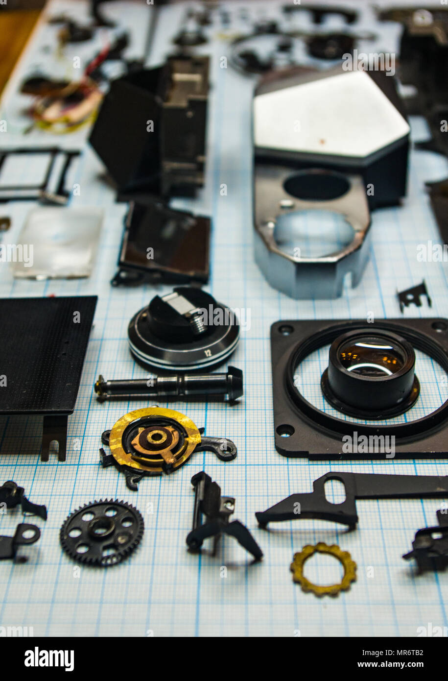 parts are completely disassembled old retro film SLR camera on graph ...