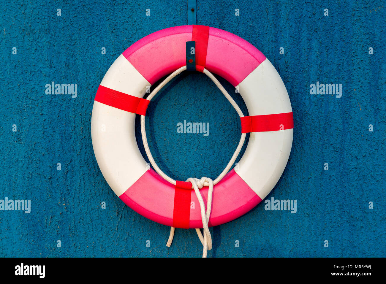red and white life belt hanging on blue wall Stock Photo - Alamy