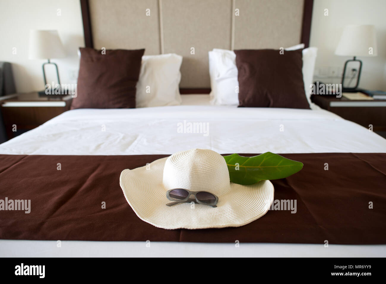 hat with sunglasses on bed in hotel room Stock Photo - Alamy
