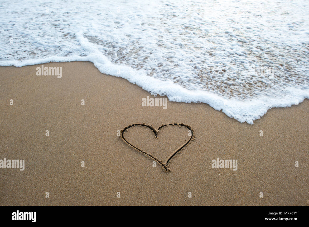 heart shape sign erasing by ocean wave on sandy beach Stock Photo - Alamy