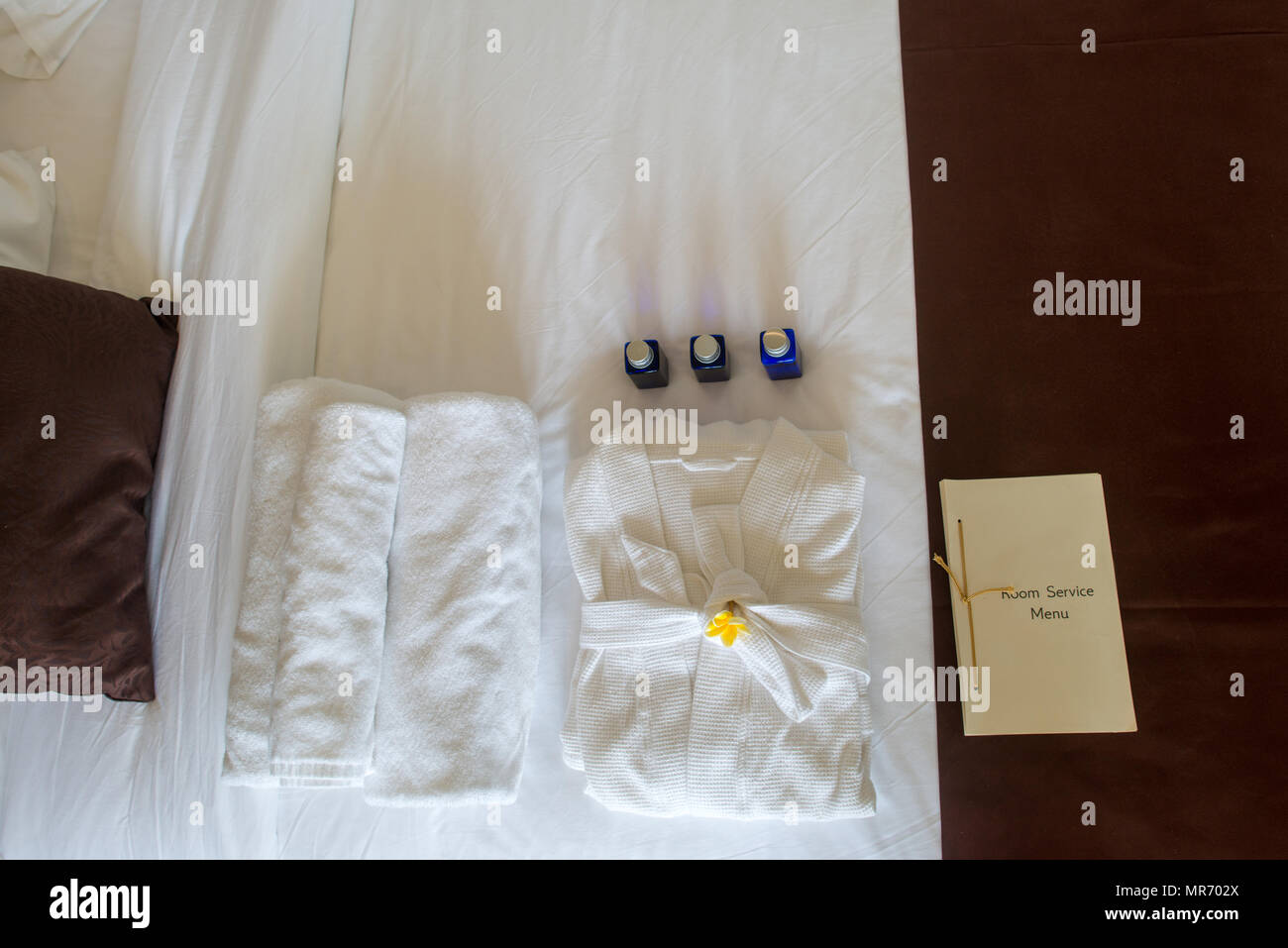 top view of rolled towels and bathrobe on bed in hotel room Stock Photo ...