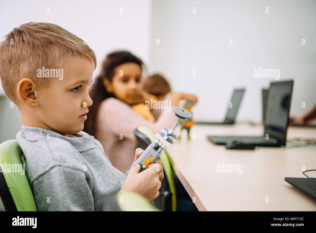 side view of serious little kid with diy robot Stock Photo - Alamy