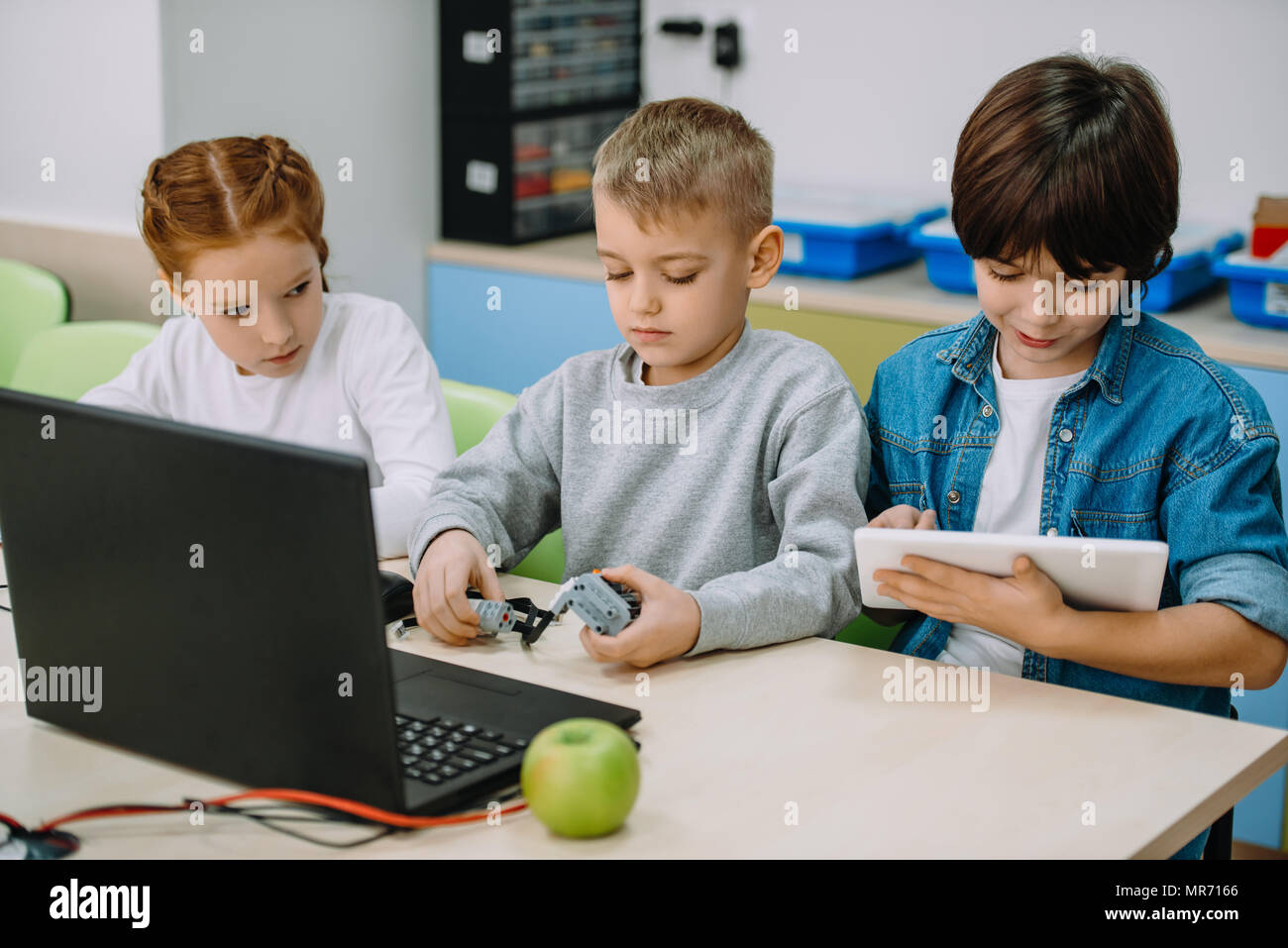 group of kids working together to construct robot, stem education ...