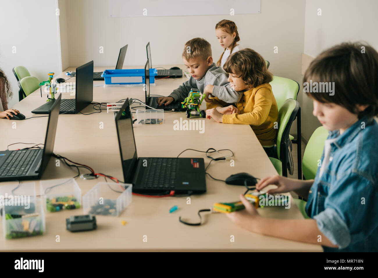 group of concentrated kids working on projects at stem education class ...