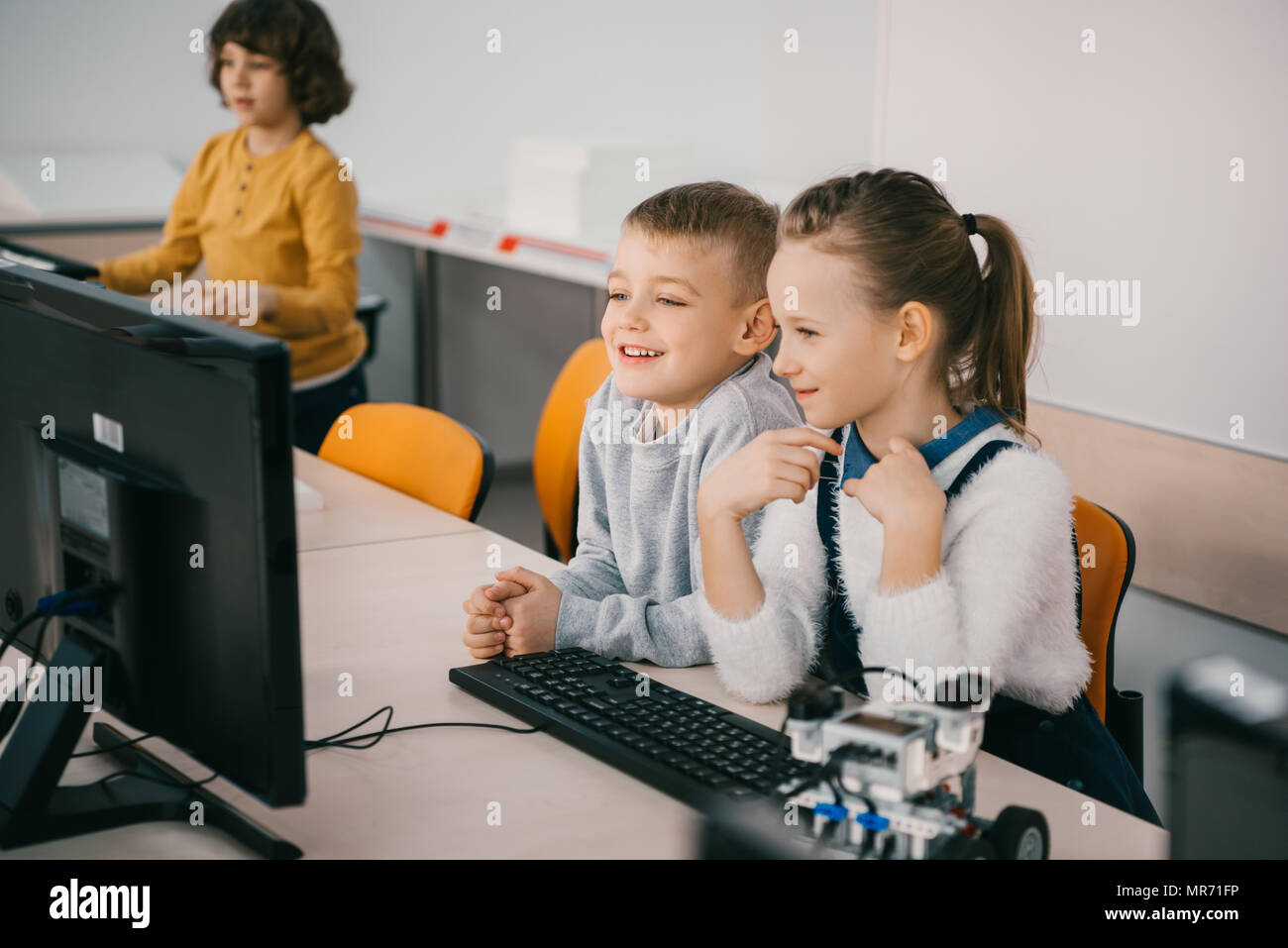 happy kids working with computer together at machinery class Stock ...