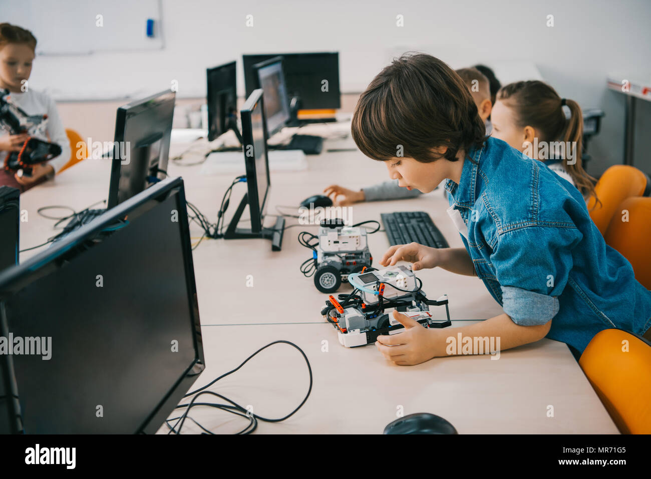 concentrated teen child constructing robot at class, stem education ...
