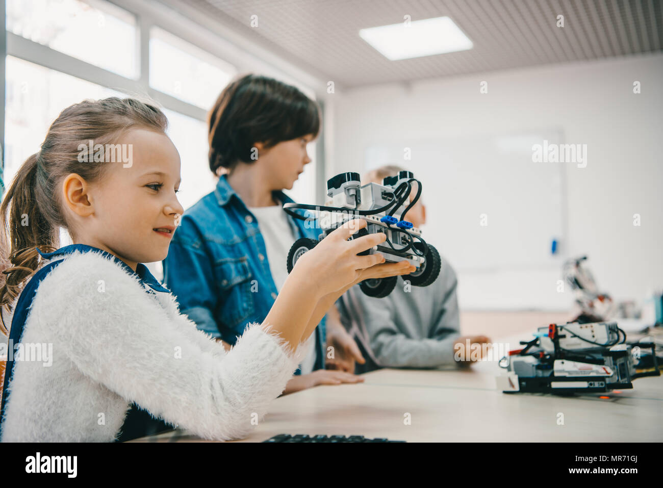 little kids sitting at class with diy robot, stem education concept ...