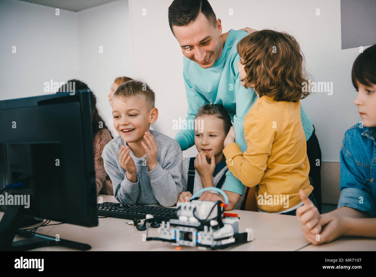 teacher helping his teen students with diy robot on stem education ...
