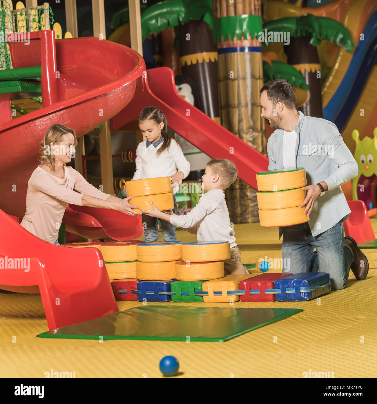happy family with two little kids playing together in entertainment ...
