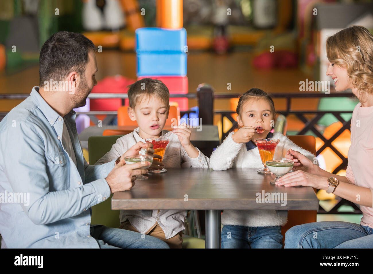 happy family with two kids eating desserts in cafe Stock Photo - Alamy