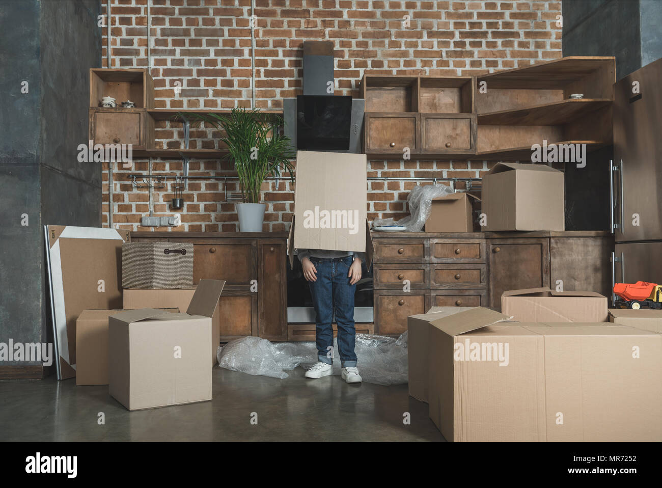 little boy standing with cardboard box on head while moving home Stock ...