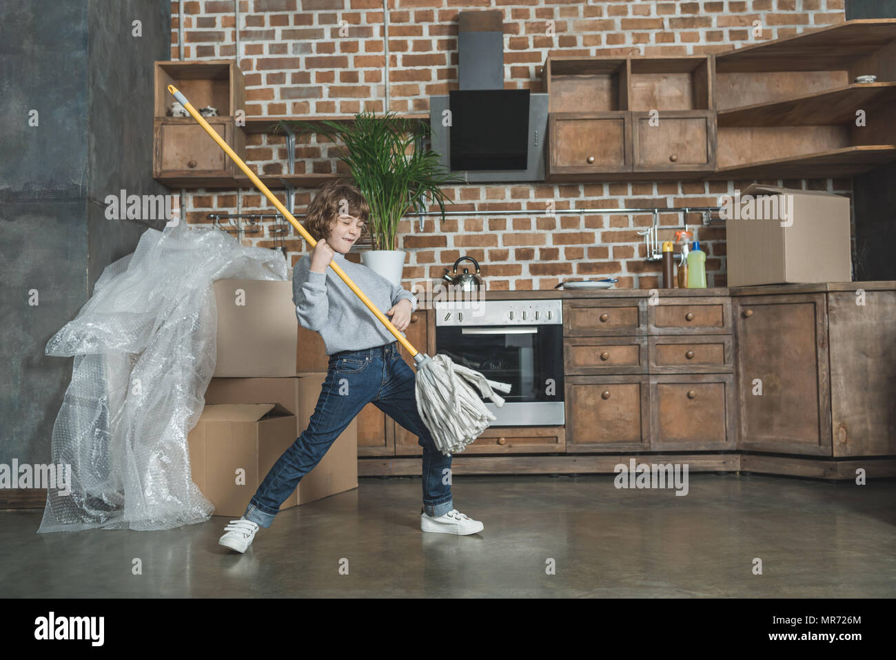 adorable happy little boy playing with mop in new house Stock Photo - Alamy