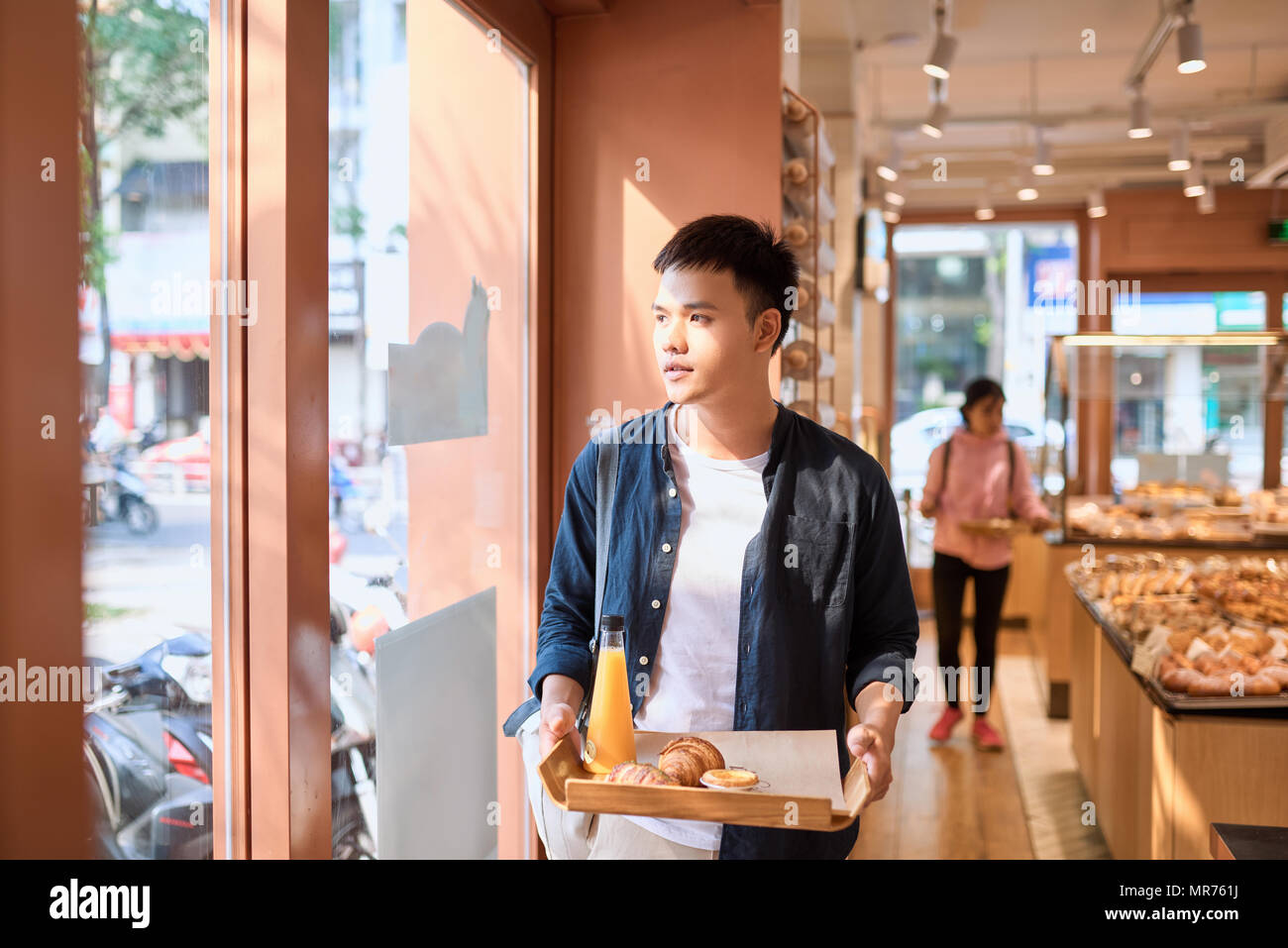 Handsome asian man buying bakery for coffee break in the afternoon ...