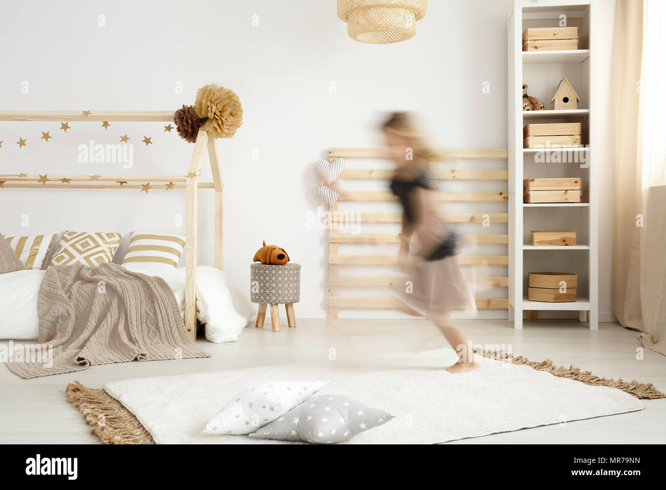 Girl running in a scandinavian style bedroom Stock Photo - Alamy