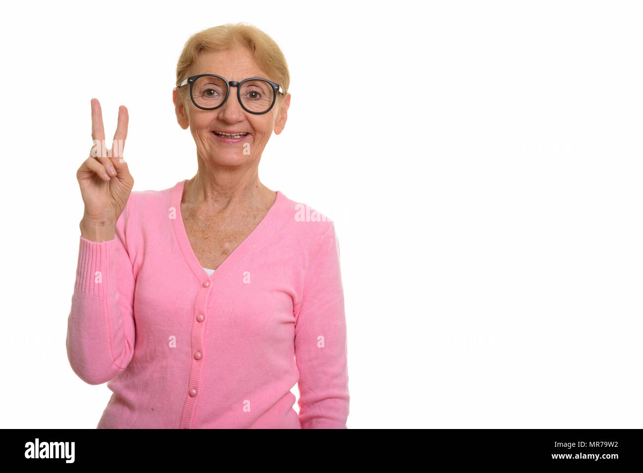 Happy senior nerd woman smiling and giving peace sign Stock Photo - Alamy