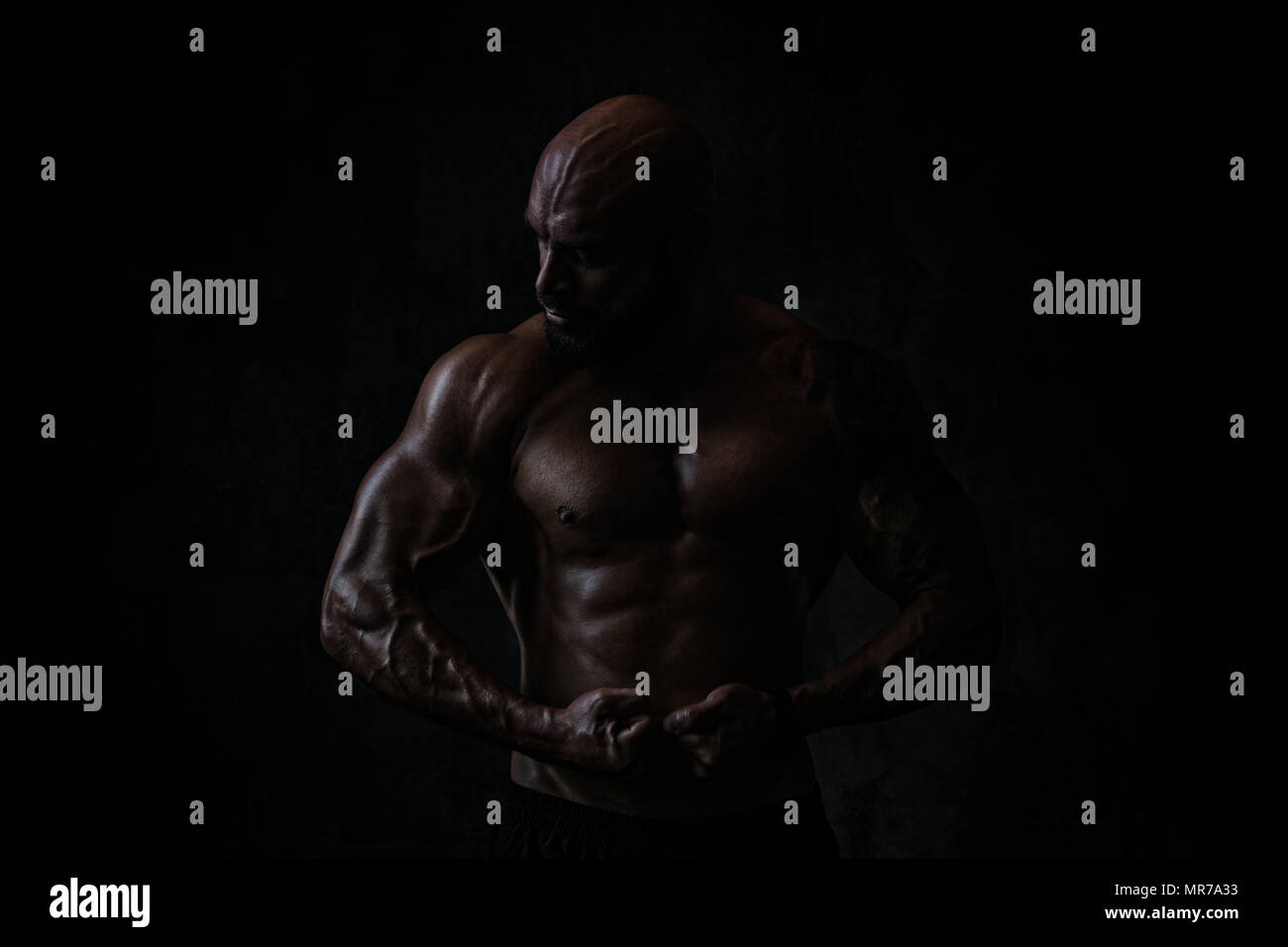 Strong man bodybuilder. Very dark dramatic colors. Tattoo on hand Stock ...