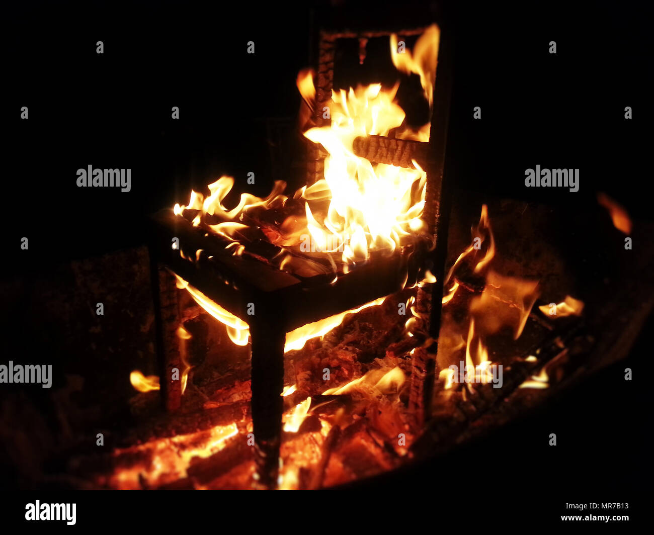 Wooden chair burning inside bonfire Stock Photo - Alamy