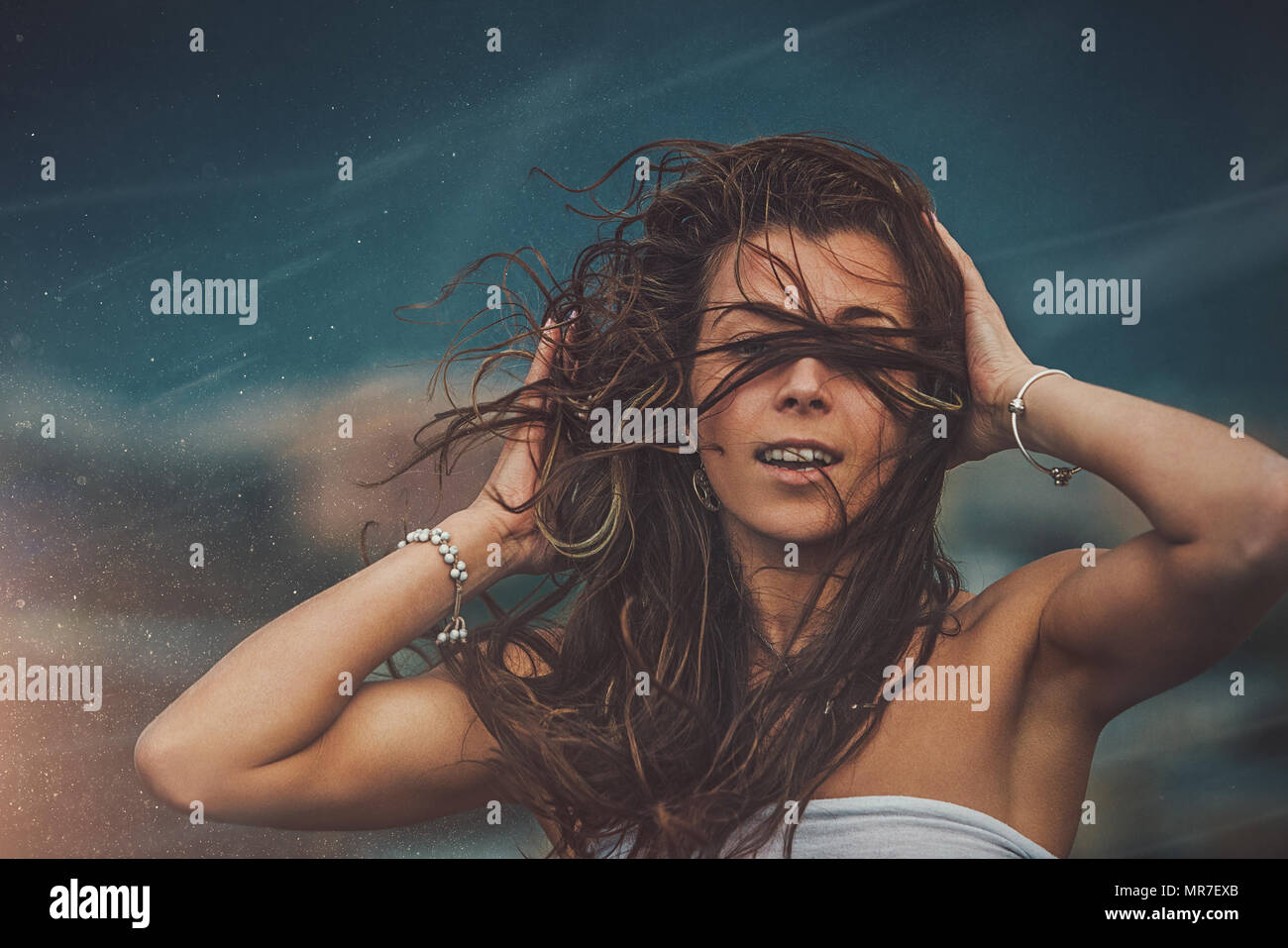 Young woman windy outdoors twilight portrait. Strong wind with ...