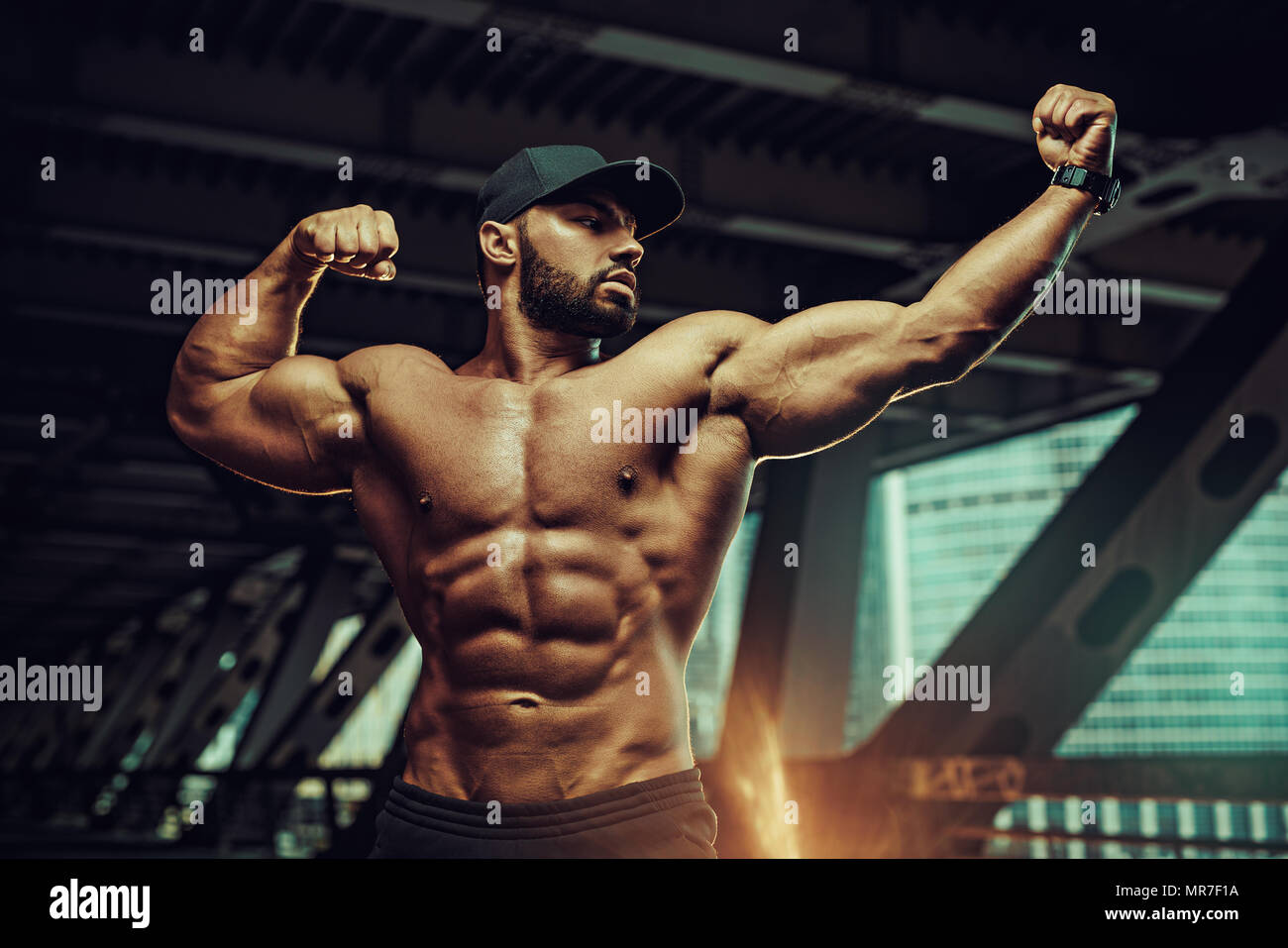 Young strong man bodybuilder standing in urban city interior Stock ...