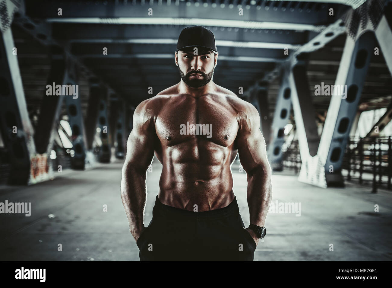 Young strong man bodybuilder standing in urban city interior Stock ...