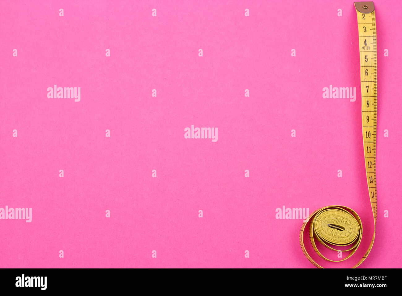Measuring tape of the tailor on the pink background Stock Photo - Alamy