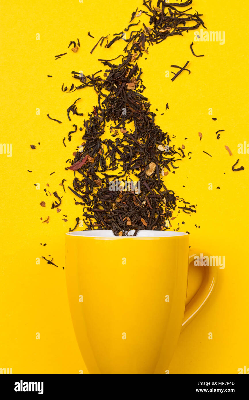 Falling driedn teain cup on yellow background white background Stock ...