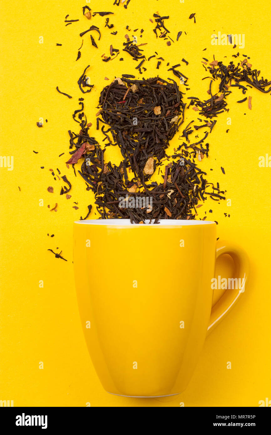 Falling driedn teain cup on yellow background white background Stock ...
