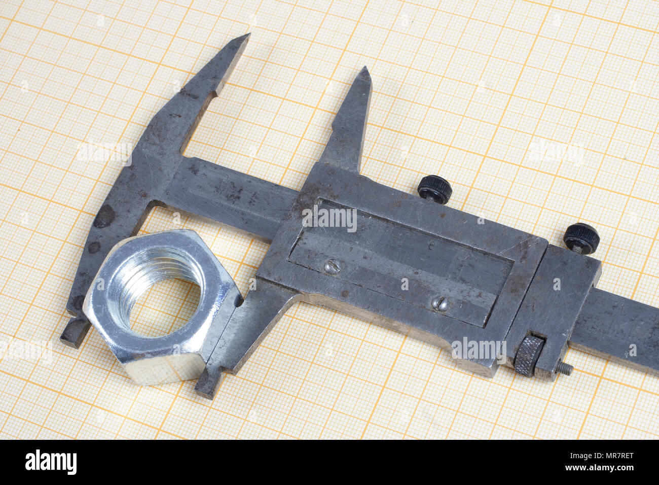 Screw, Nuts and caliper on graph paper background Stock Photo - Alamy