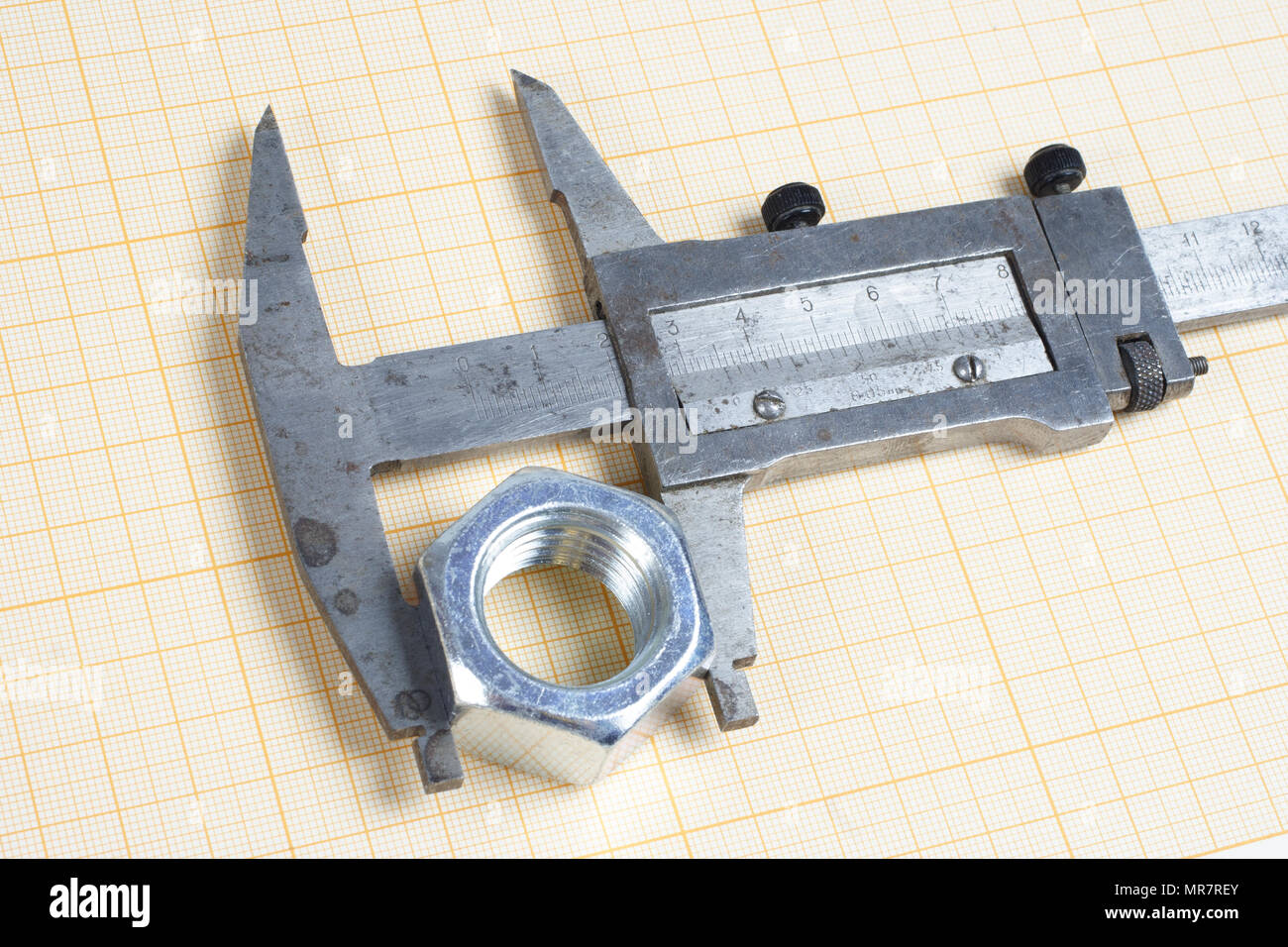 Screw, Nuts and caliper on graph paper background Stock Photo - Alamy