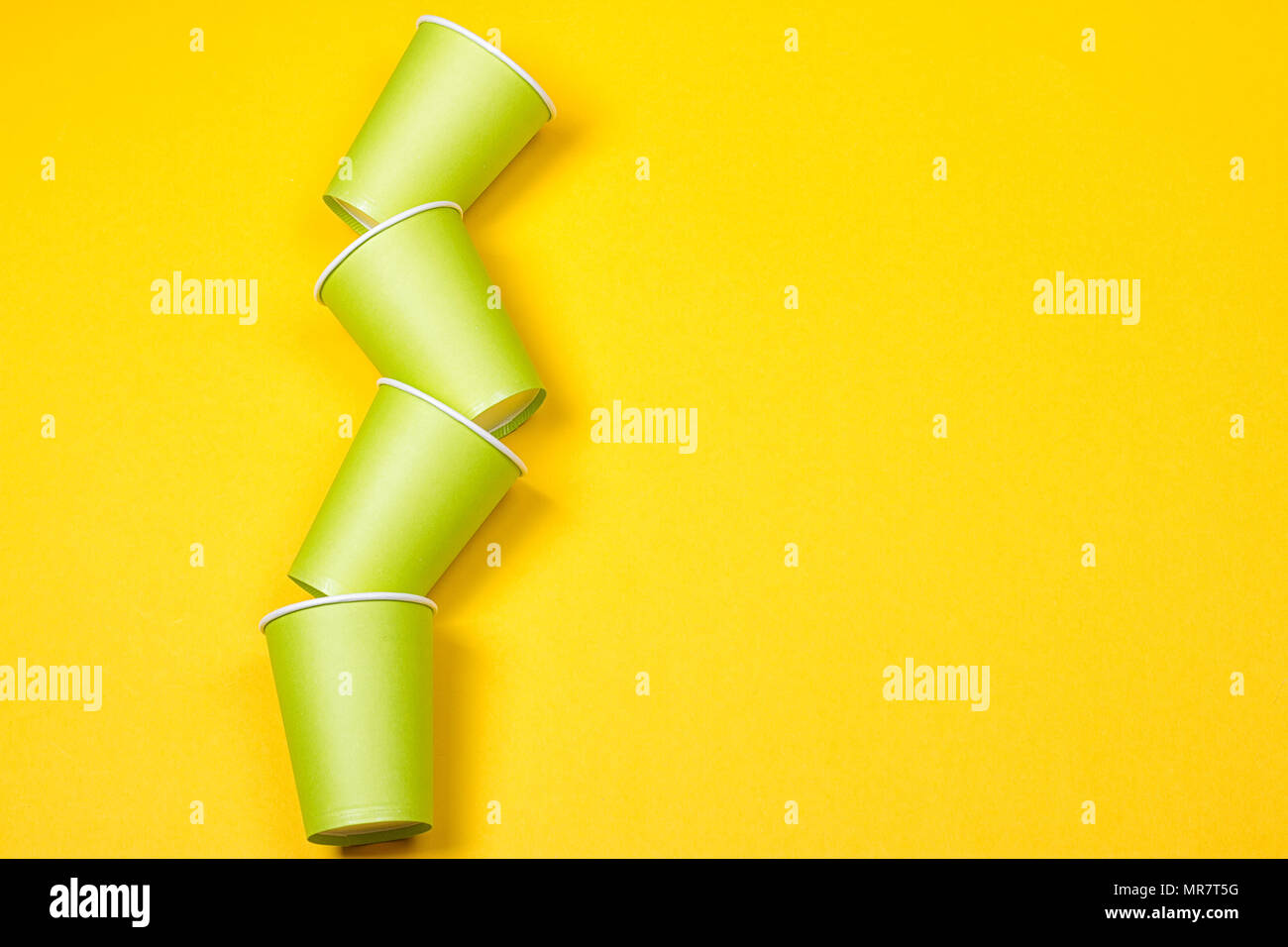Set of green paper cups on a yellow background Stock Photo - Alamy